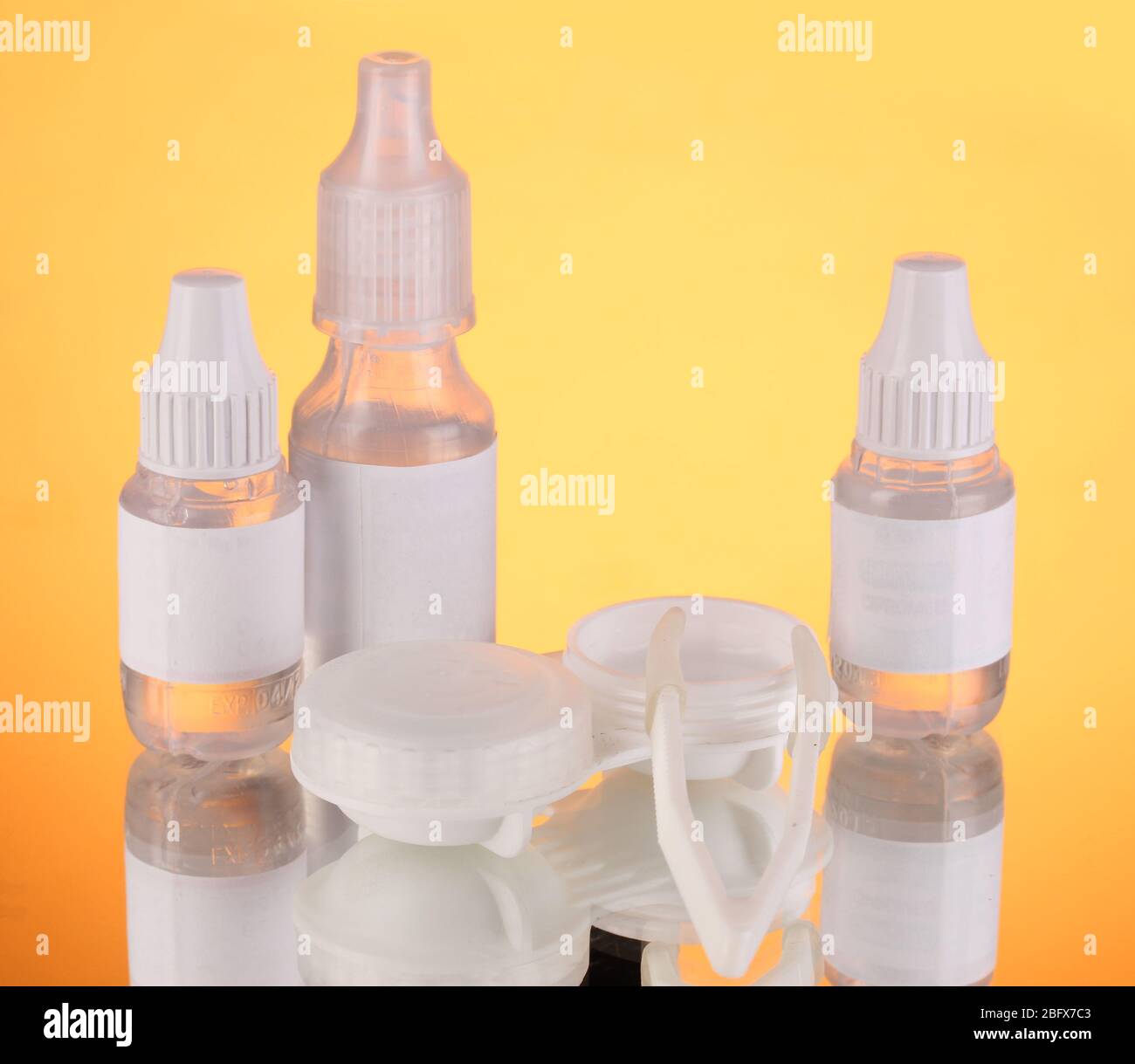Eye drops and lenses on orange background Stock Photo - Alamy