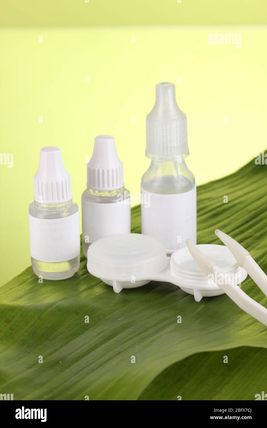 Eye drops and lenses on leaf on green background Stock Photo - Alamy