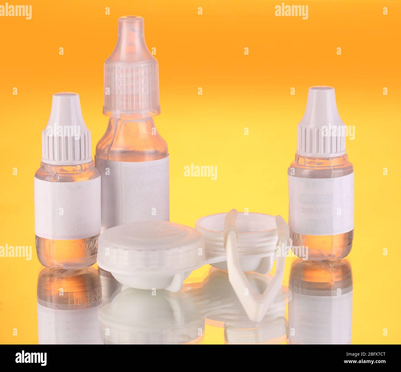 Eye drops and lenses on orange background Stock Photo - Alamy