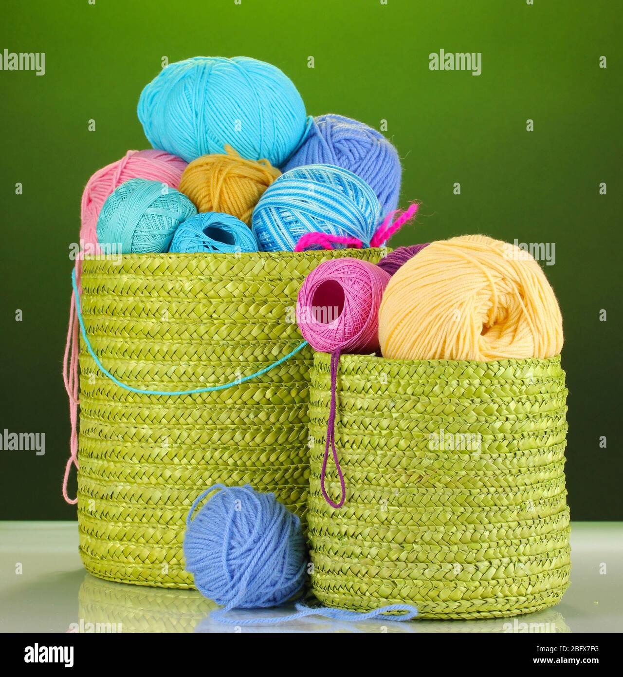 Colorful yarn for knitting in green basket on green background Stock ...