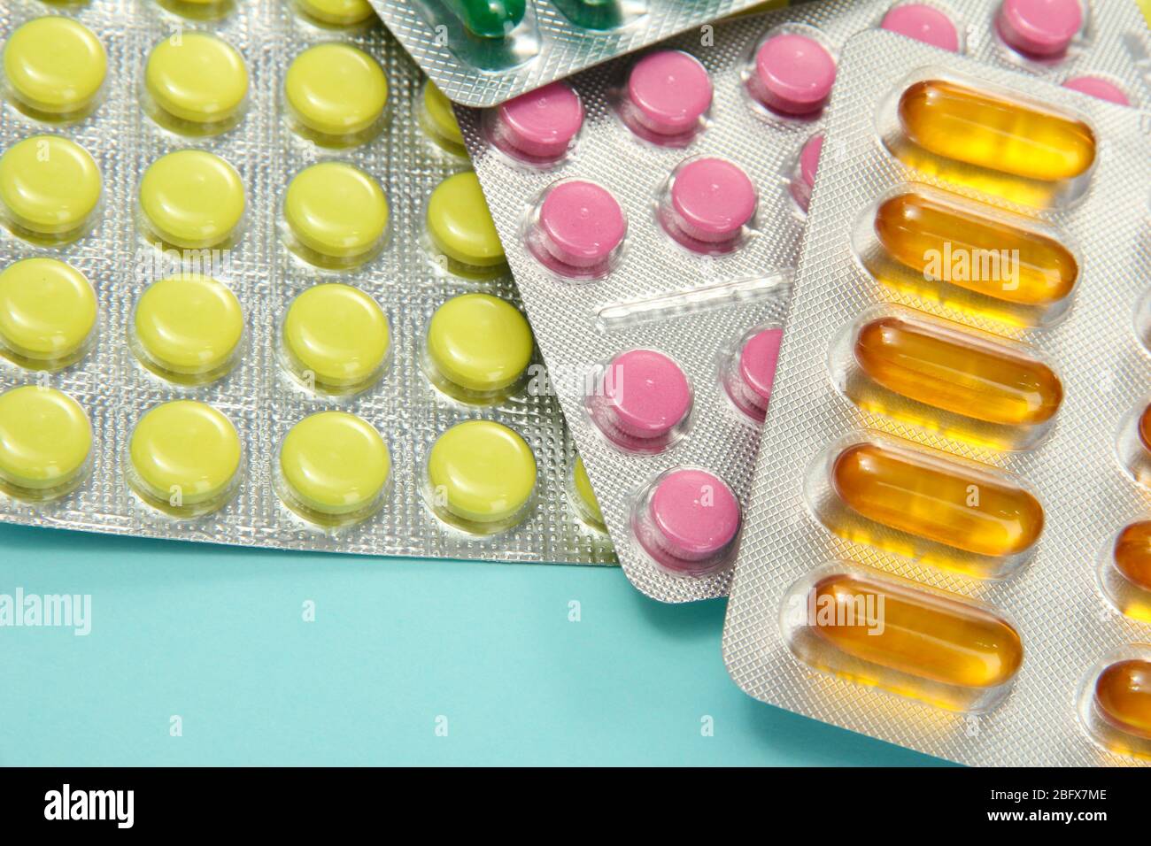 Capsules and pills packed in blisters, on blue background Stock Photo ...