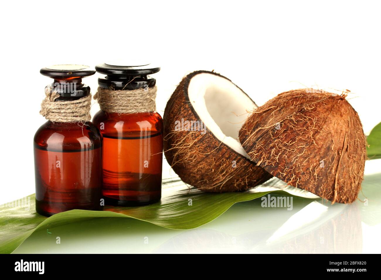 coconut oil in bottles with coconuts on white background Stock Photo ...