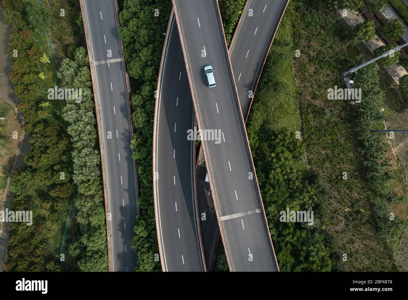 Aerial view of single car driving on highway and overpass Stock Photo ...