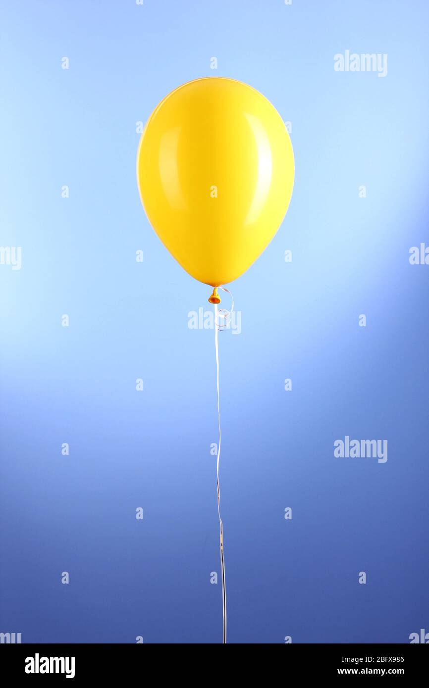 Yellow one balloon on blue background Stock Photo - Alamy