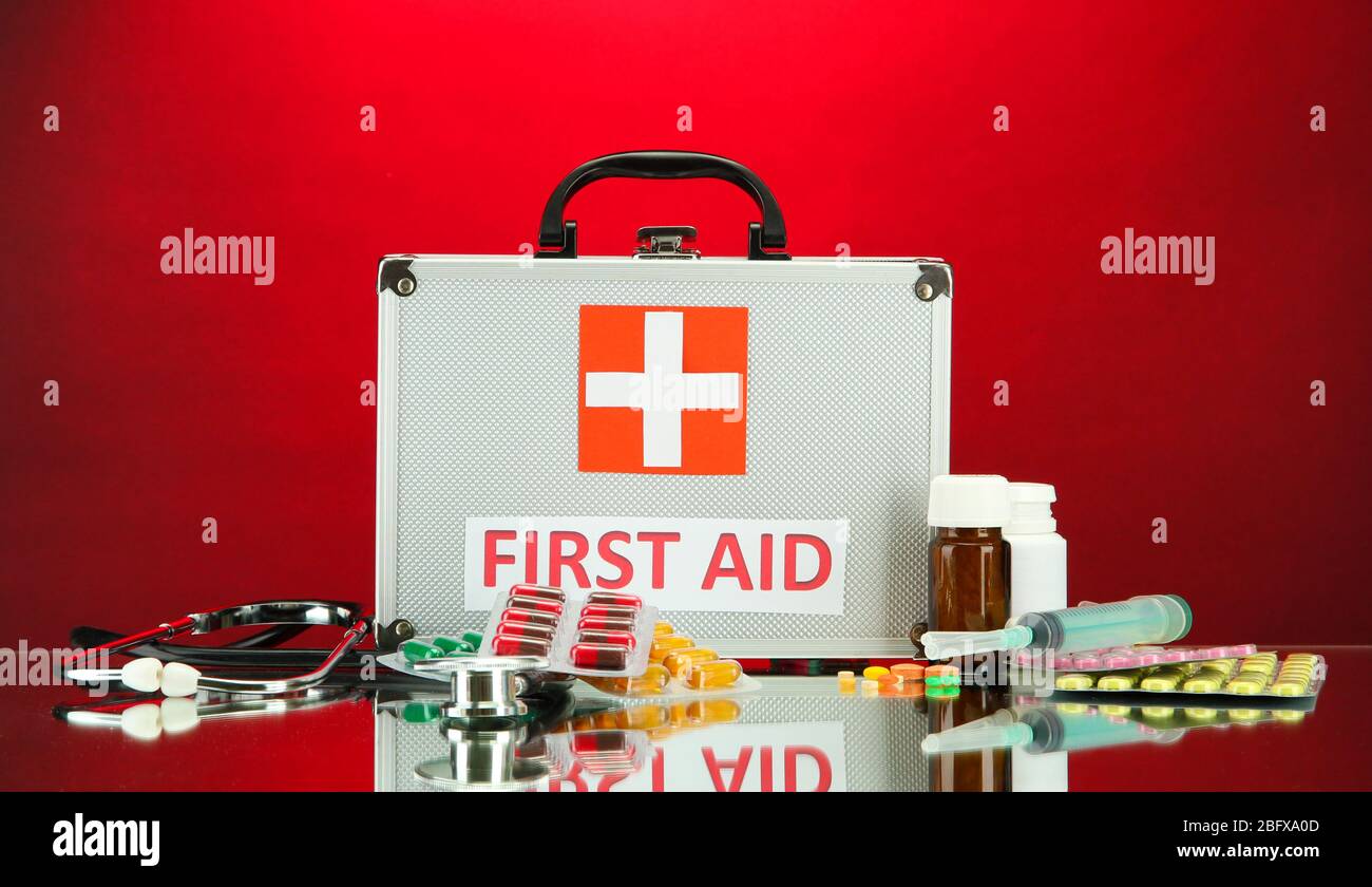 First aid box, on red background Stock Photo - Alamy