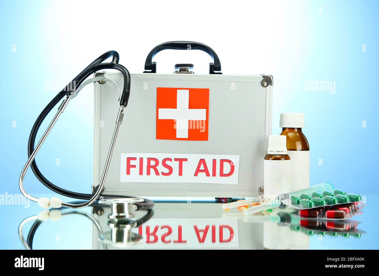 First aid box, on blue background Stock Photo - Alamy