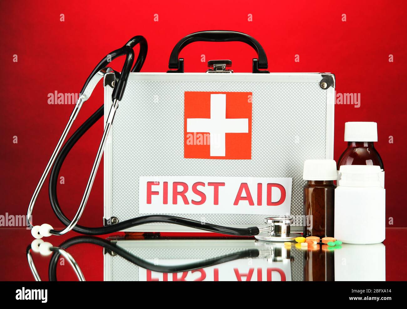 First aid box, on red background Stock Photo - Alamy