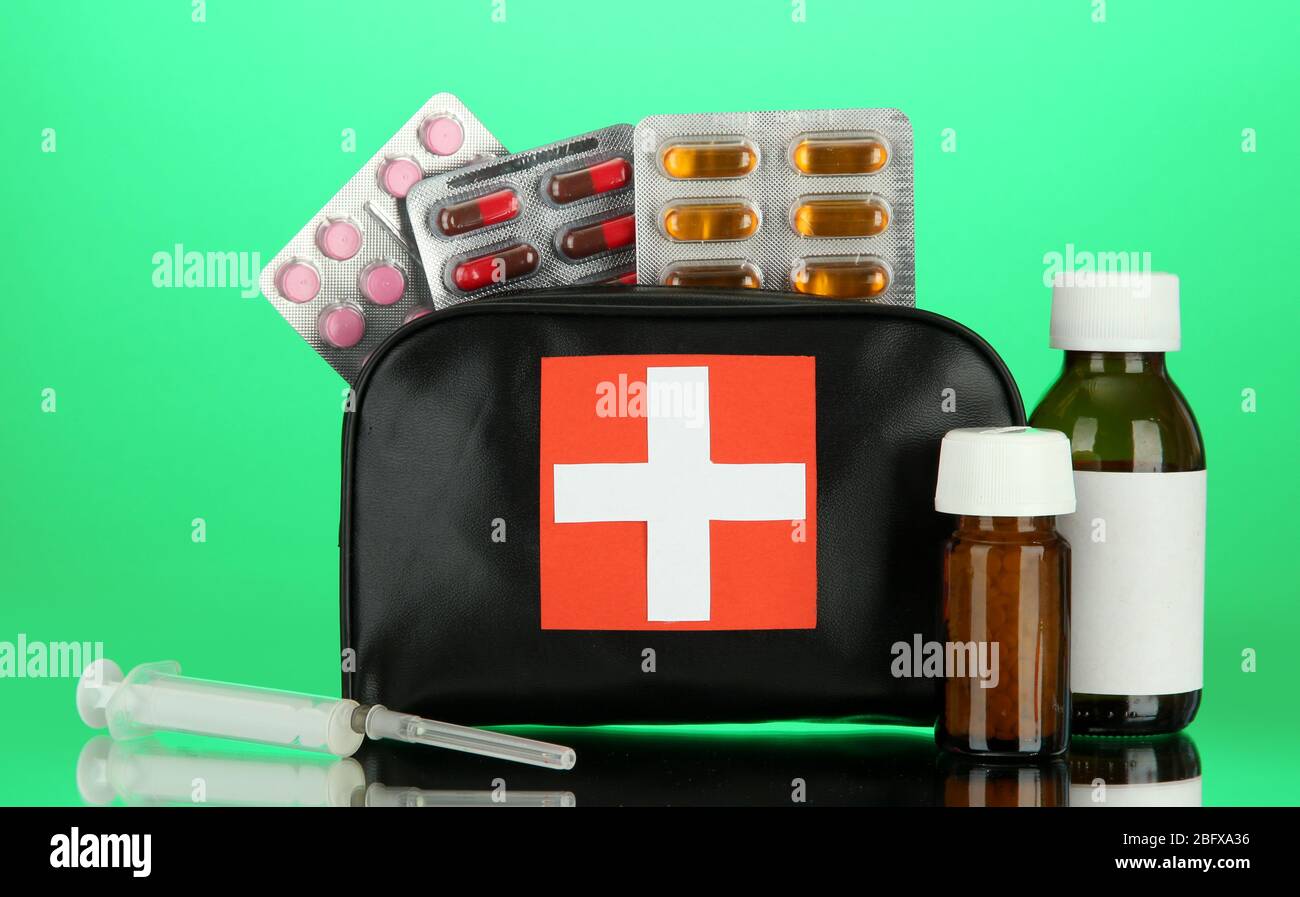 First aid bag, on green background Stock Photo - Alamy