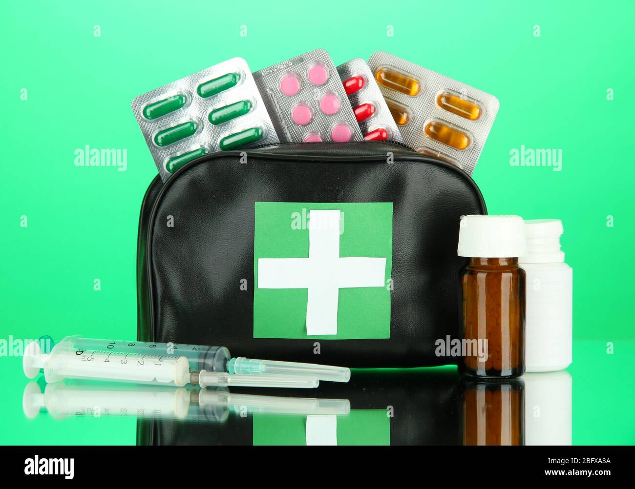 First aid bag, on green background Stock Photo - Alamy