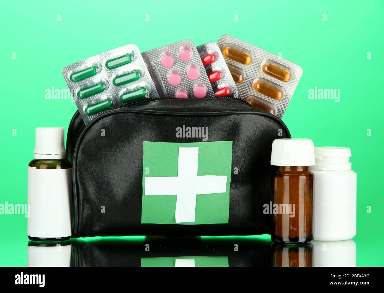 First aid bag, on green background Stock Photo - Alamy