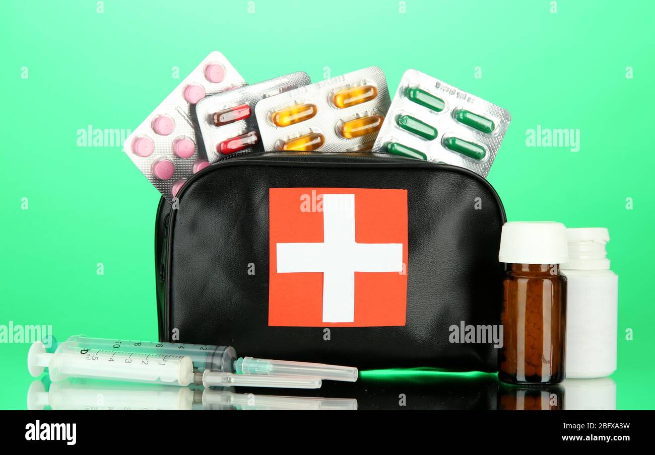 First aid bag, on green background Stock Photo - Alamy