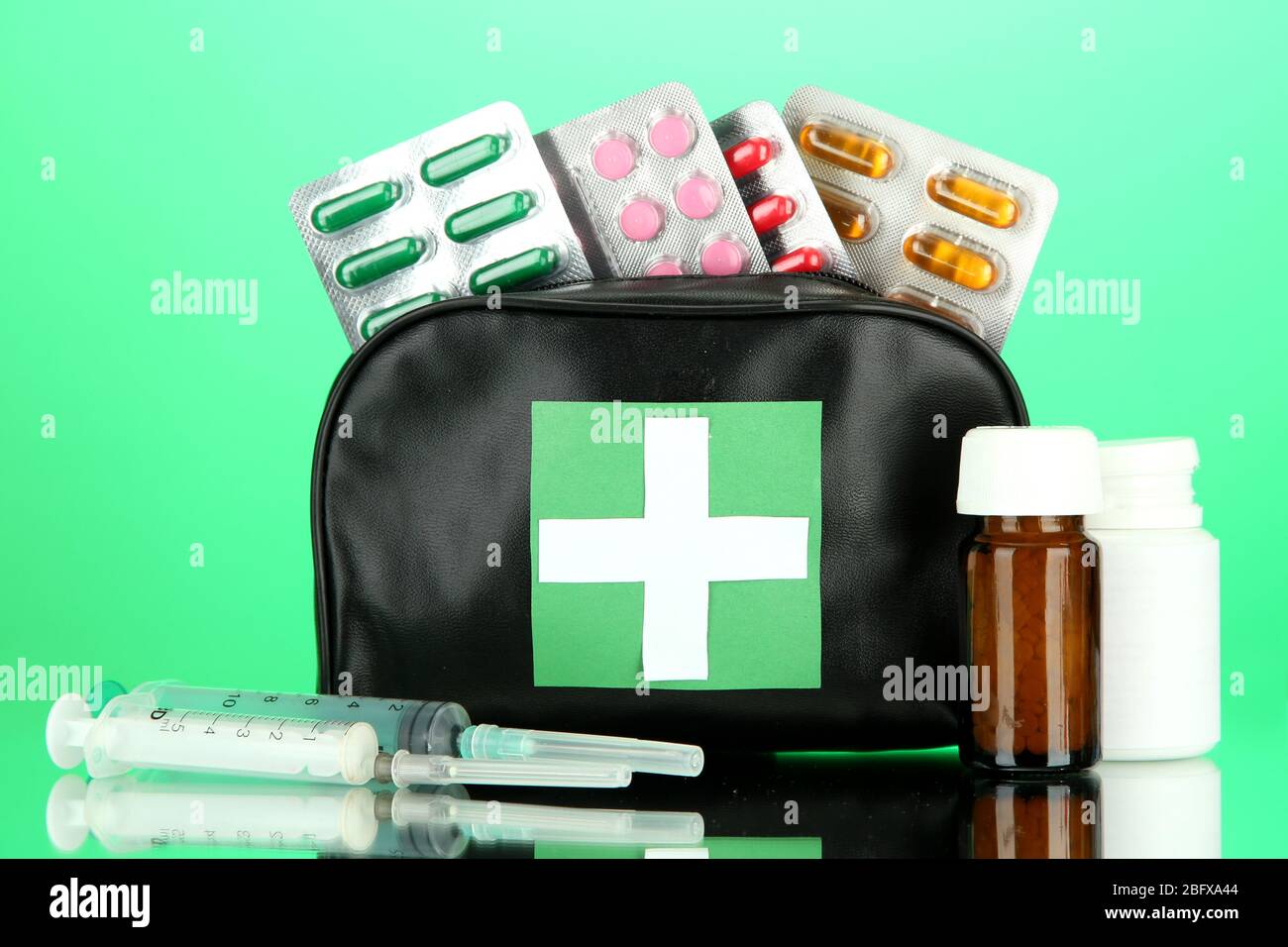 First aid bag, on green background Stock Photo - Alamy