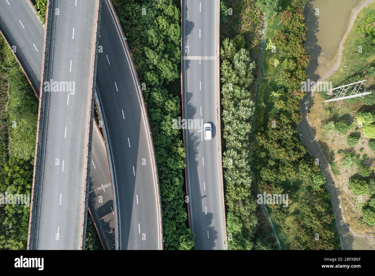 Aerial view of single car driving on highway and overpass Stock Photo ...