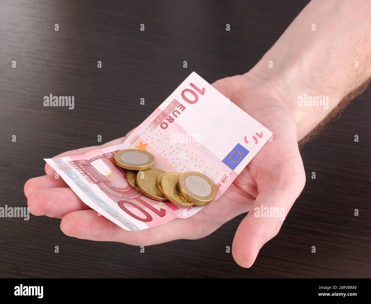 Counting money in hand on wooden table background Stock Photo - Alamy