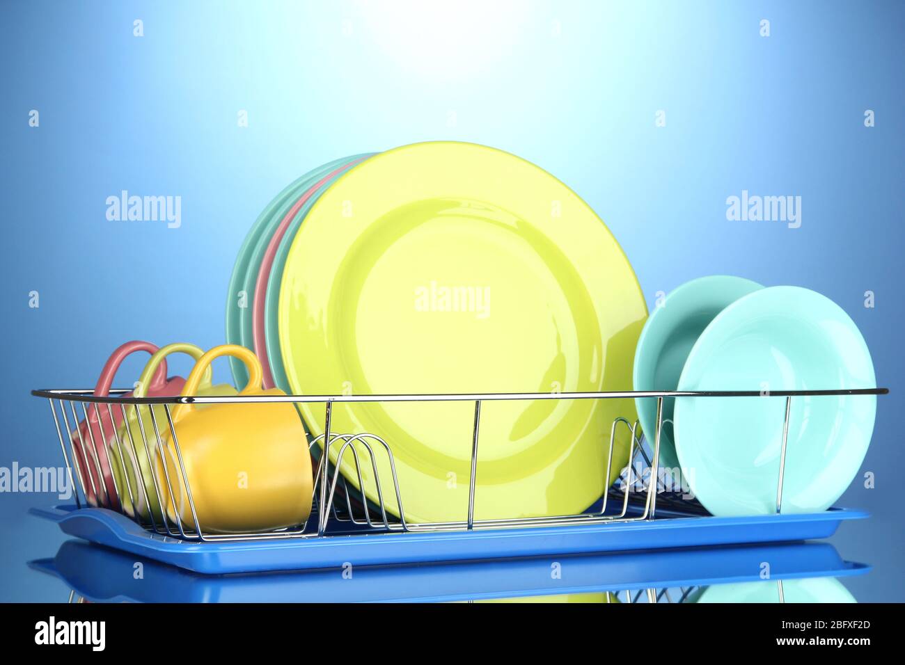 Color plates in rack on blue background Stock Photo - Alamy
