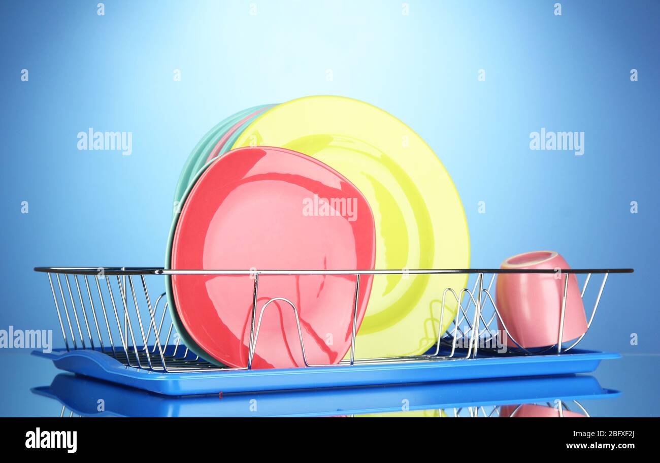 Color plates in rack on blue background Stock Photo - Alamy