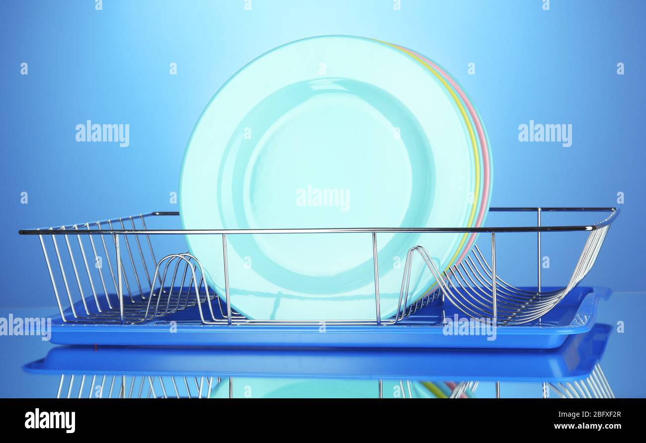 Color plates in rack on blue background Stock Photo - Alamy