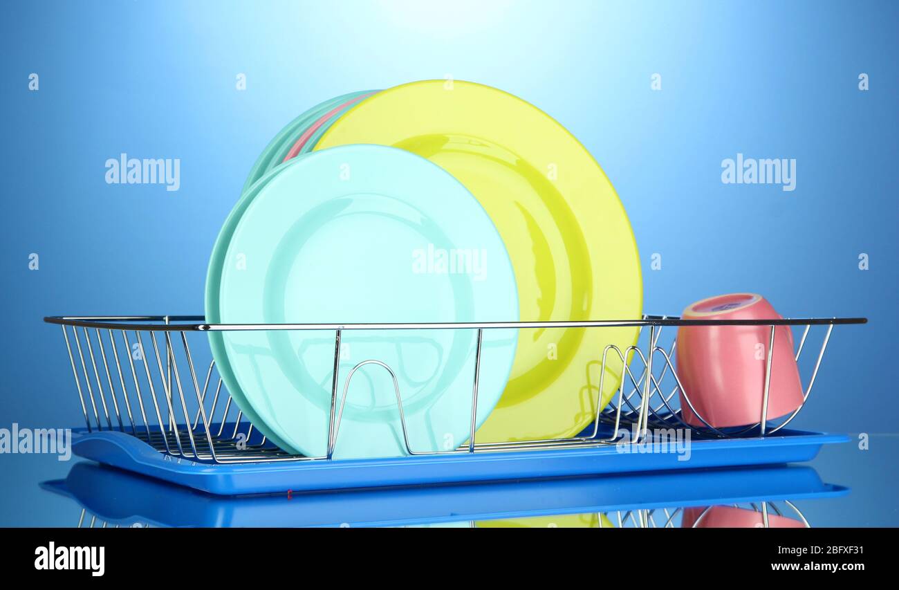 Color plates in rack on blue background Stock Photo - Alamy