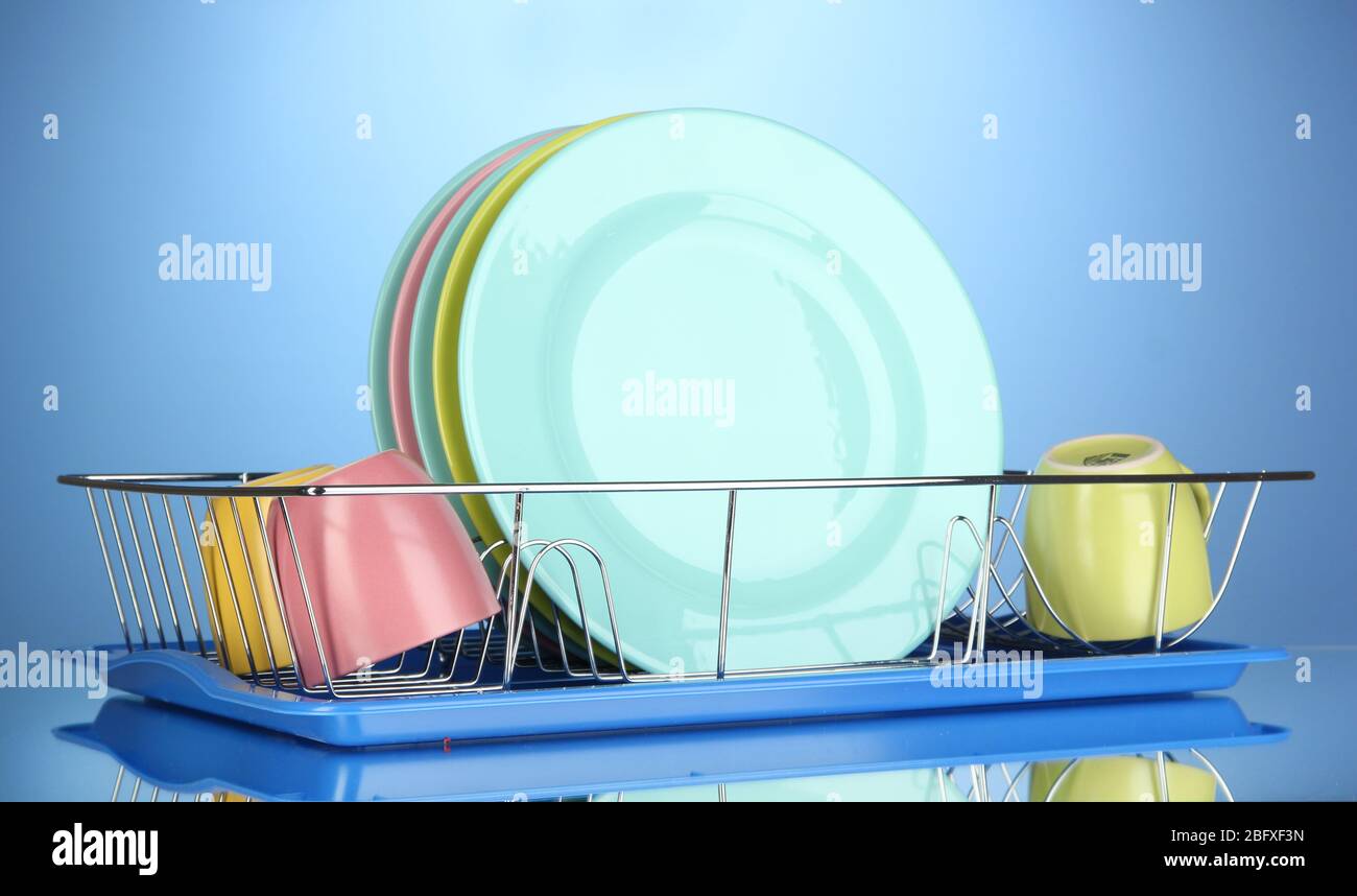 Color plates in rack on blue background Stock Photo - Alamy