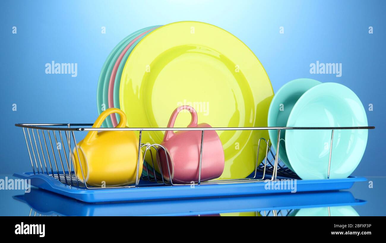 Color plates in rack on blue background Stock Photo - Alamy