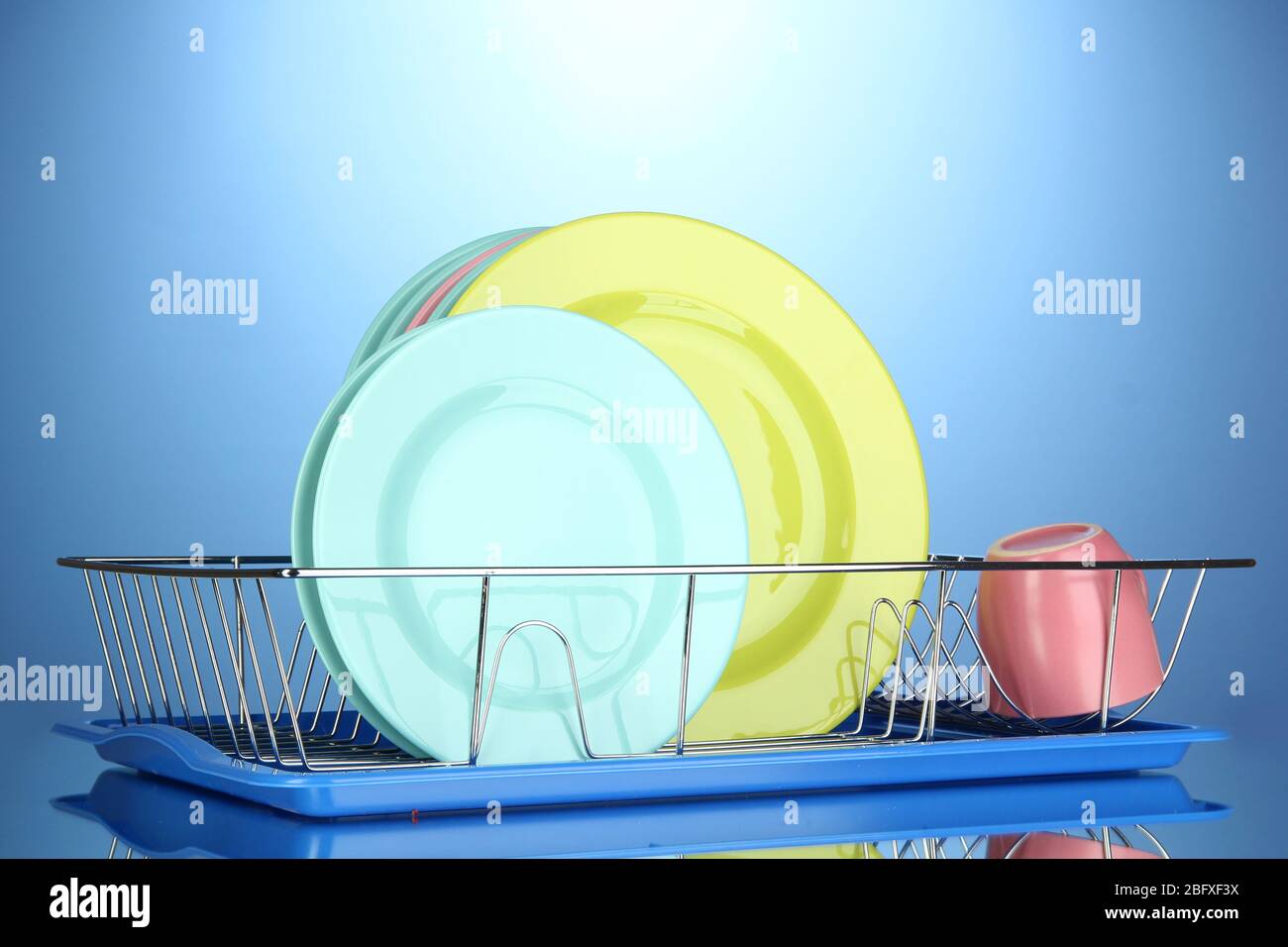 Color plates in rack on blue background Stock Photo - Alamy