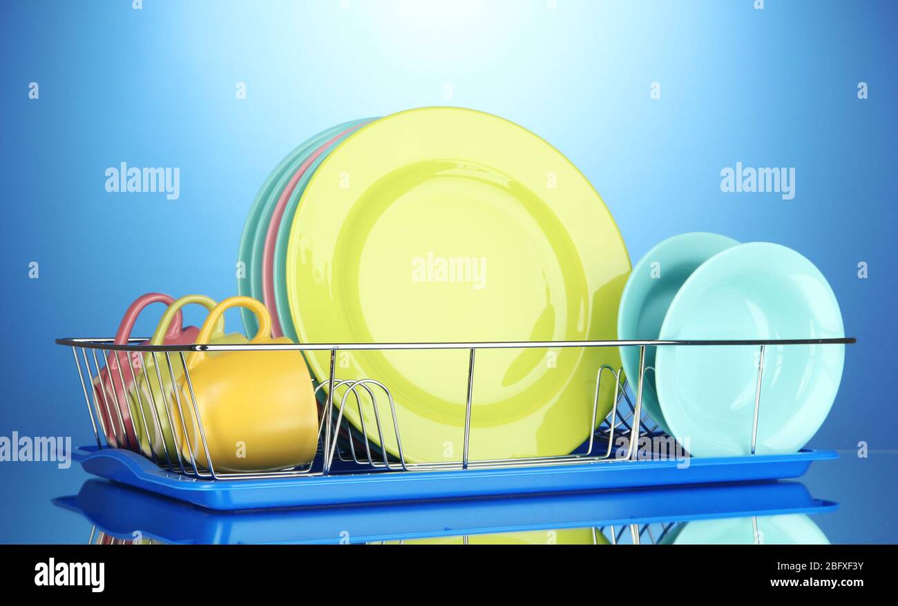 Color plates in rack on blue background Stock Photo - Alamy