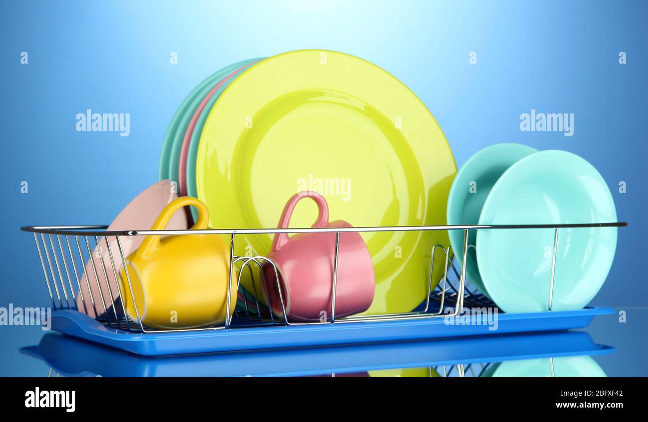 Color plates in rack on blue background Stock Photo - Alamy
