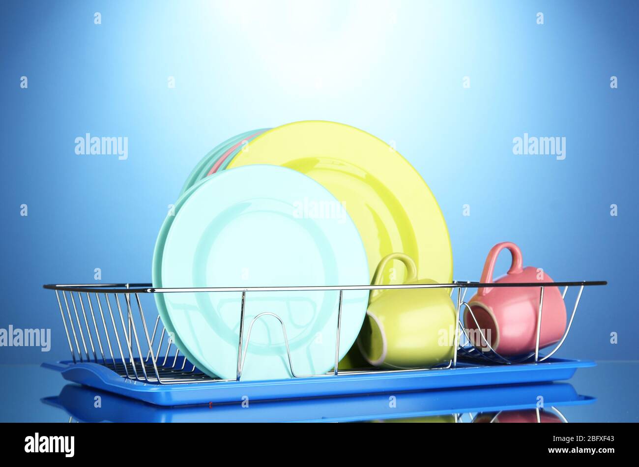 Color plates in rack on blue background Stock Photo - Alamy