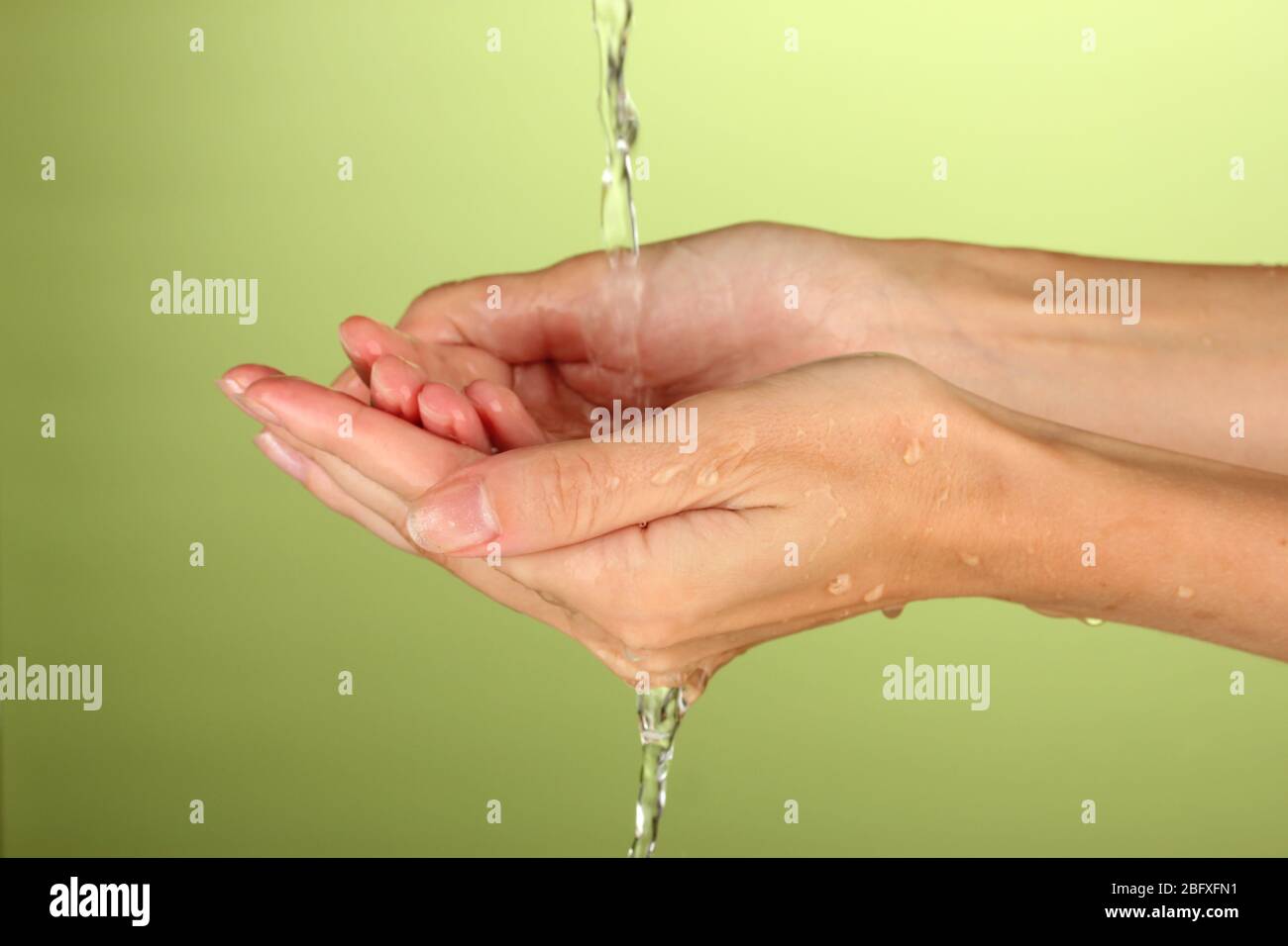 Washing hands on green background close-up Stock Photo - Alamy