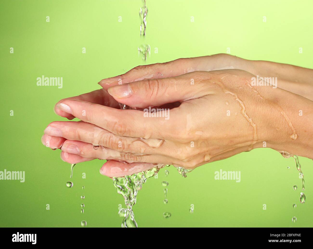 Washing hands on green background close-up Stock Photo - Alamy