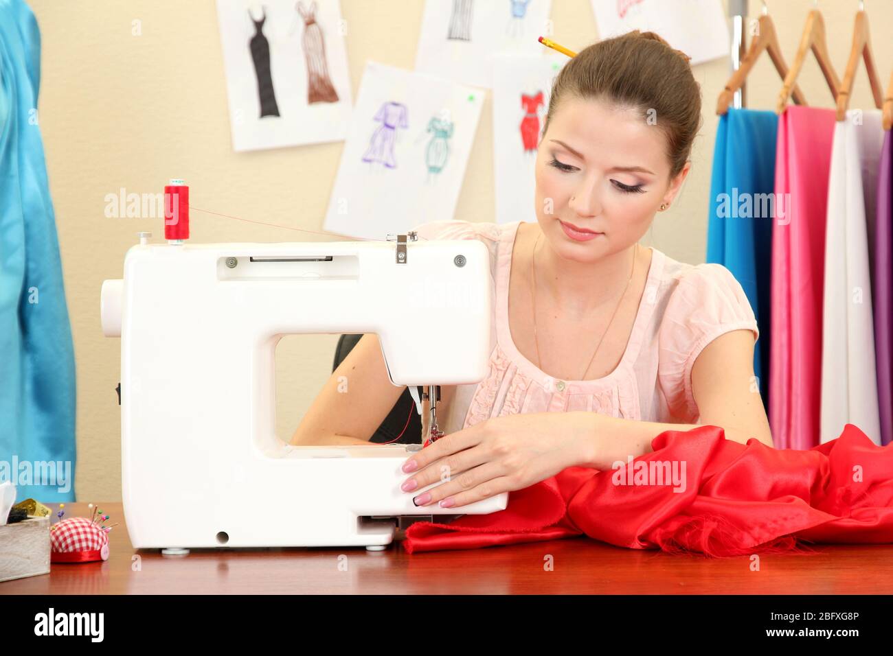 beautiful young dressmaker in workroom Stock Photo - Alamy