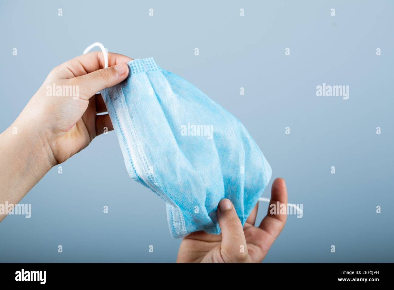 A kid holding a blue tissue medical face mask Stock Photo - Alamy