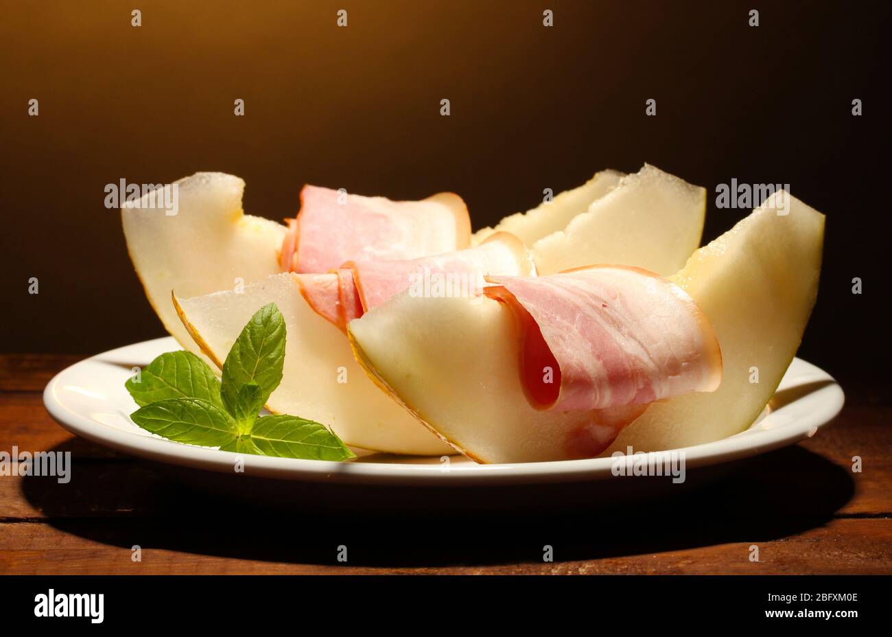 parma ham and melon, on wooden table, on brown background Stock Photo ...