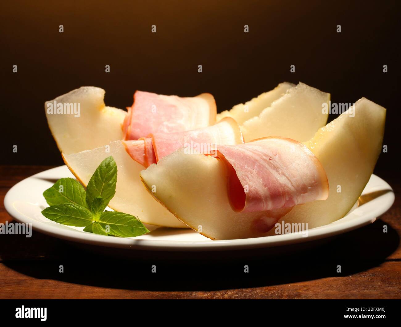 parma ham and melon, on wooden table, on brown background Stock Photo ...
