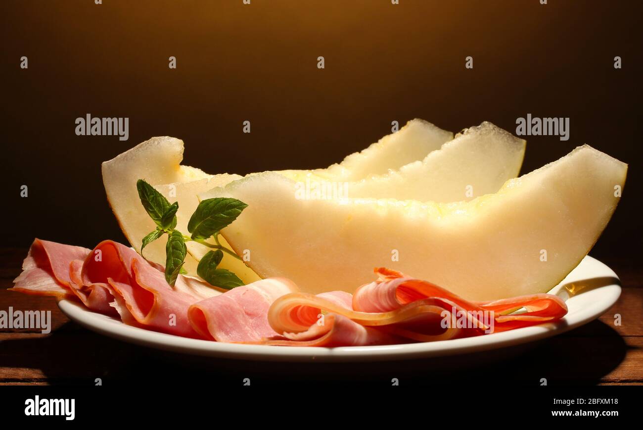 parma ham and melon, on wooden table, on brown background Stock Photo ...