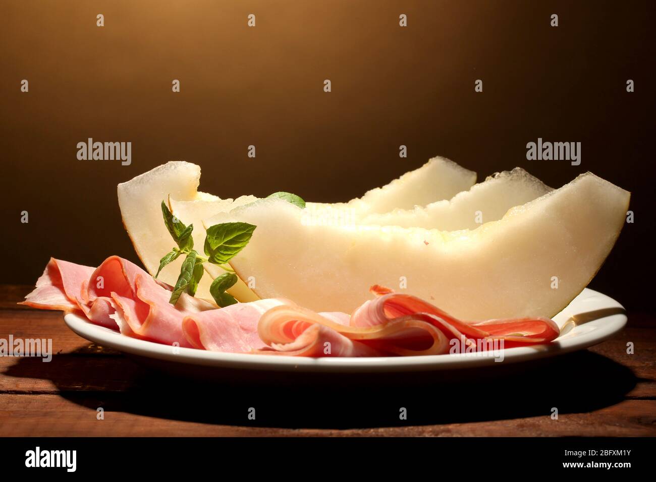 parma ham and melon, on wooden table, on brown background Stock Photo ...