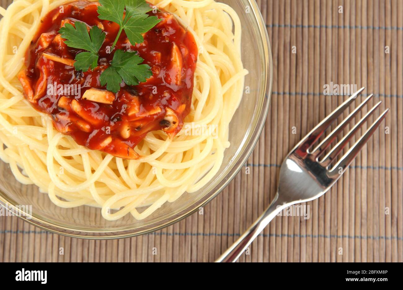Italian spaghetti in glass bowl on bamboo mat Stock Photo - Alamy