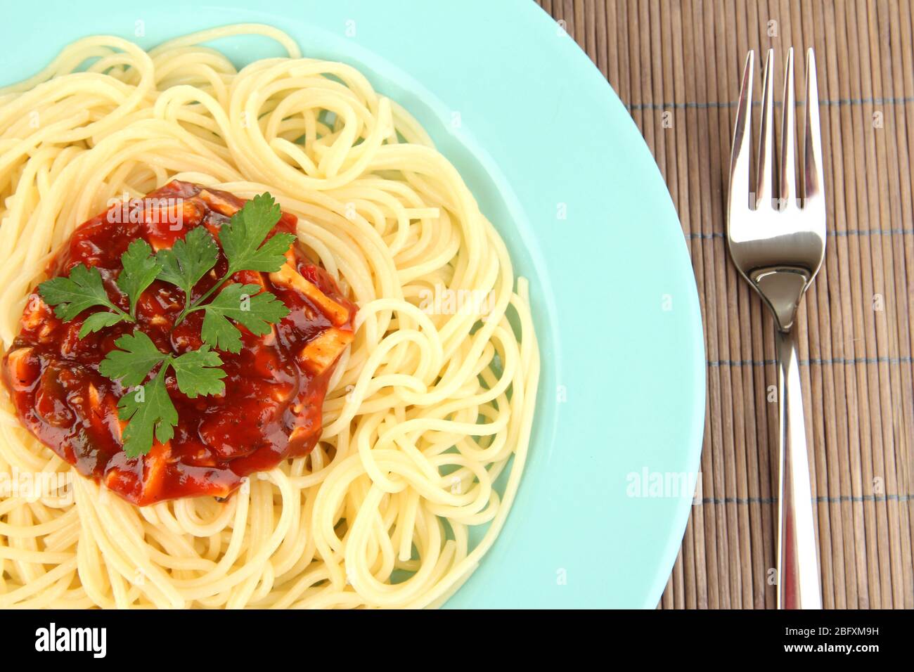 Italian spaghetti in plate on bamboo mat Stock Photo - Alamy