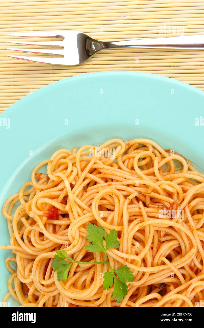 Italian spaghetti in plate on bamboo mat close-up Stock Photo - Alamy