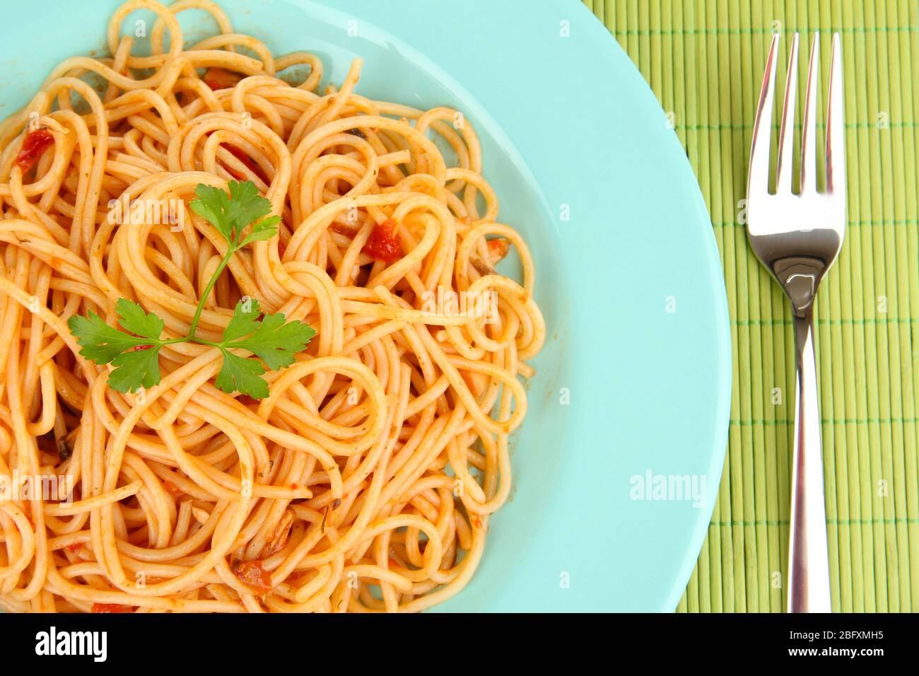 Italian spaghetti in plate on bamboo mat close-up Stock Photo - Alamy