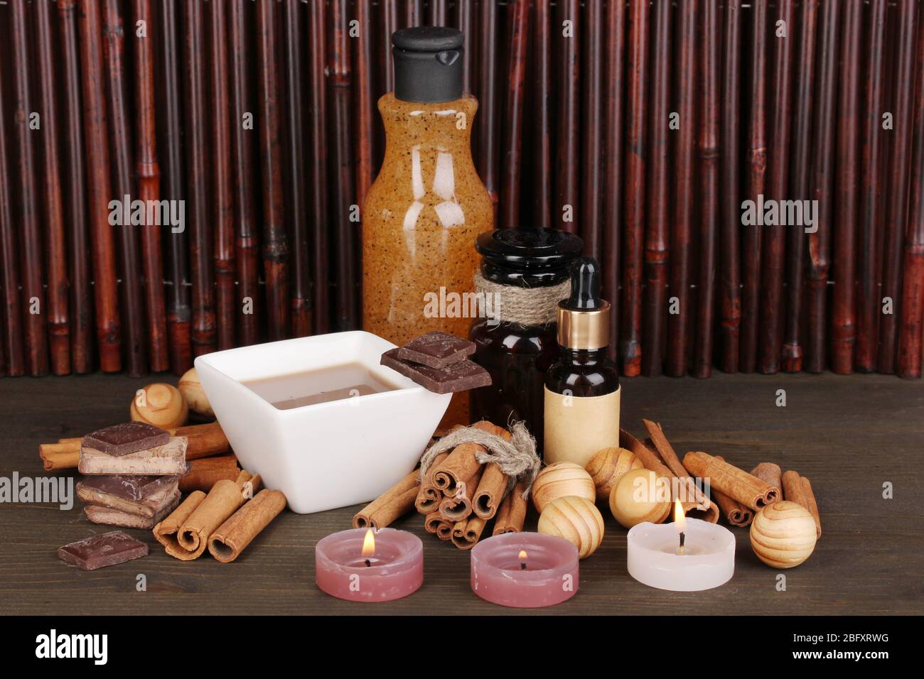 Beautiful chocolate spa setting on wooden table bamboo background with ...