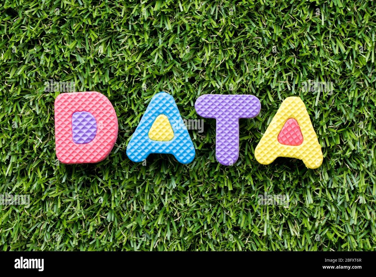 Color alphabet letter in word data on artificial green grass background ...
