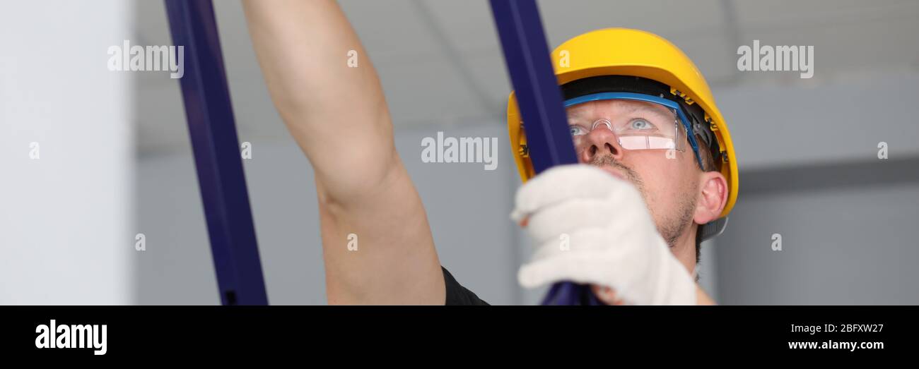 Worker climbing on ladder Stock Photo - Alamy