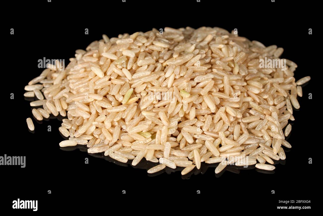 White unpolished rice isolated on black Stock Photo - Alamy