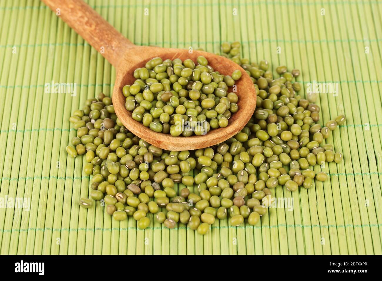 Mung beans over wooden spoon on color background Stock Photo - Alamy