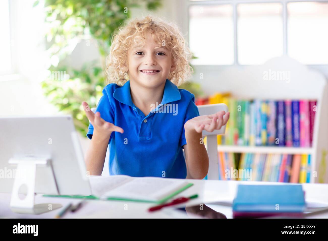 Online remote learning. School kids with computer having video ...