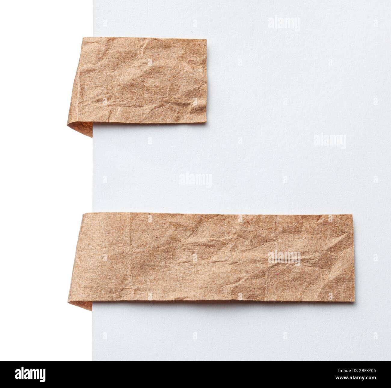 Paper ribbon bookmark or label tags. Craft crumpled paper on a white ...