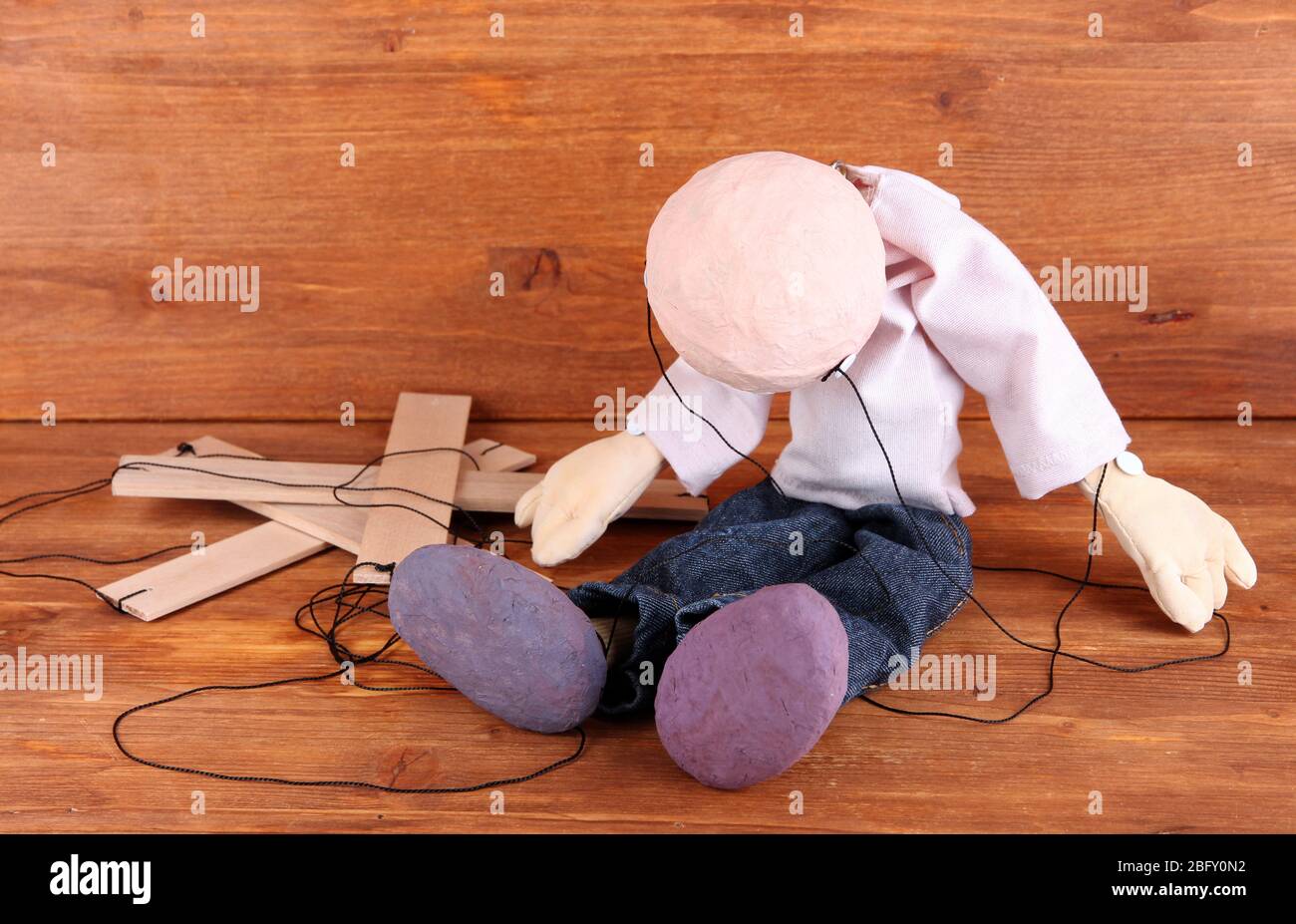 Wooden puppet sitting on wooden background Stock Photo - Alamy