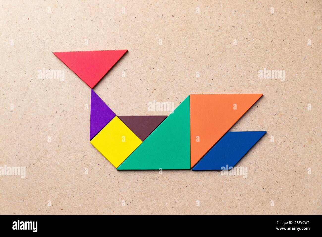 Color tangram in whale shape on wood background Stock Photo - Alamy