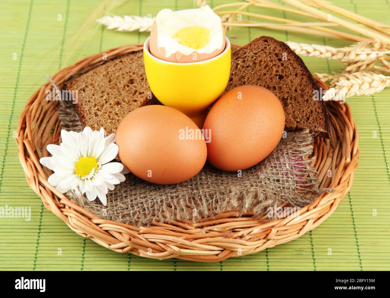 Boiled eggs on wicker matt on color background Stock Photo - Alamy